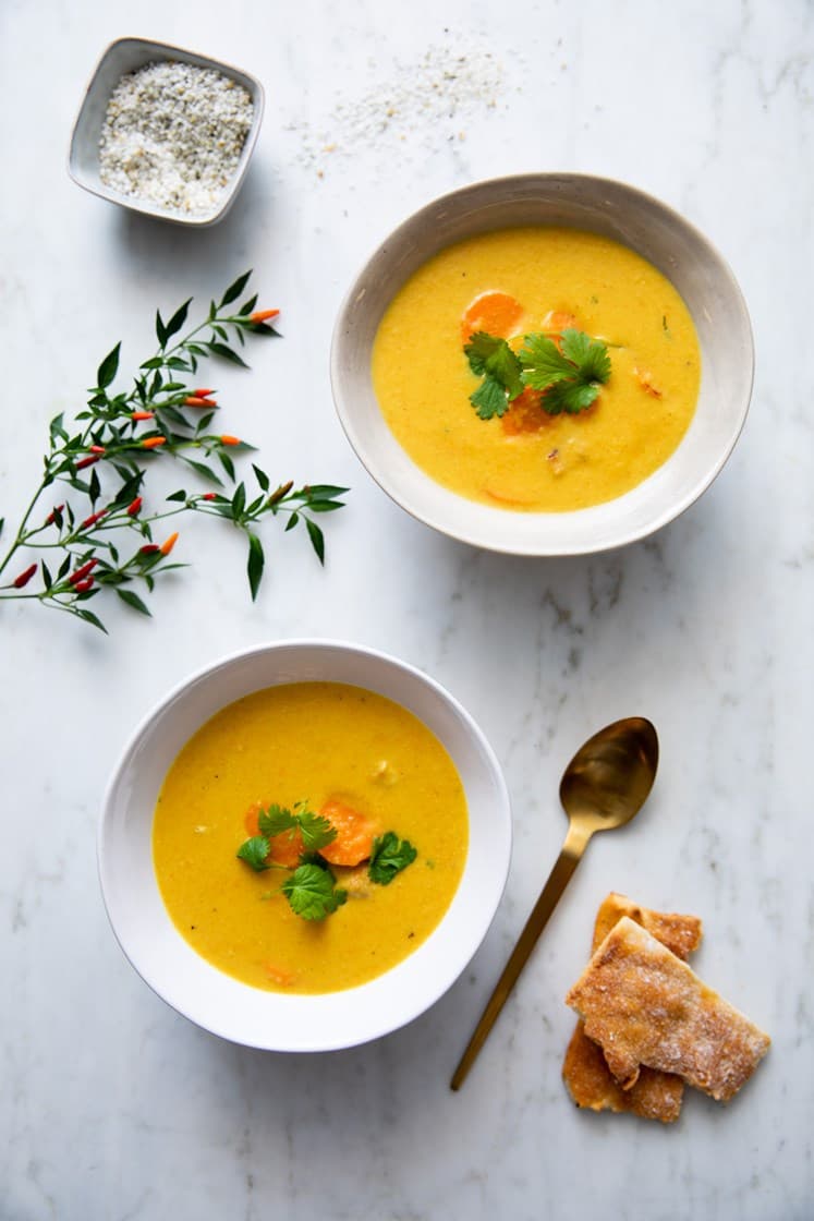 Indisk kyllingsuppe med gulrot servert med langbrød og koriander ...