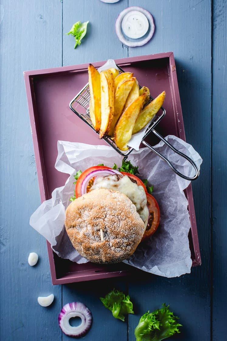 Cheeseburgere med ovnsbakte potetbåter, friske grønnsaker og ...